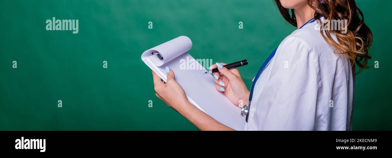 Doctor filling medical report for her patient.Doctor with stethoscope ...