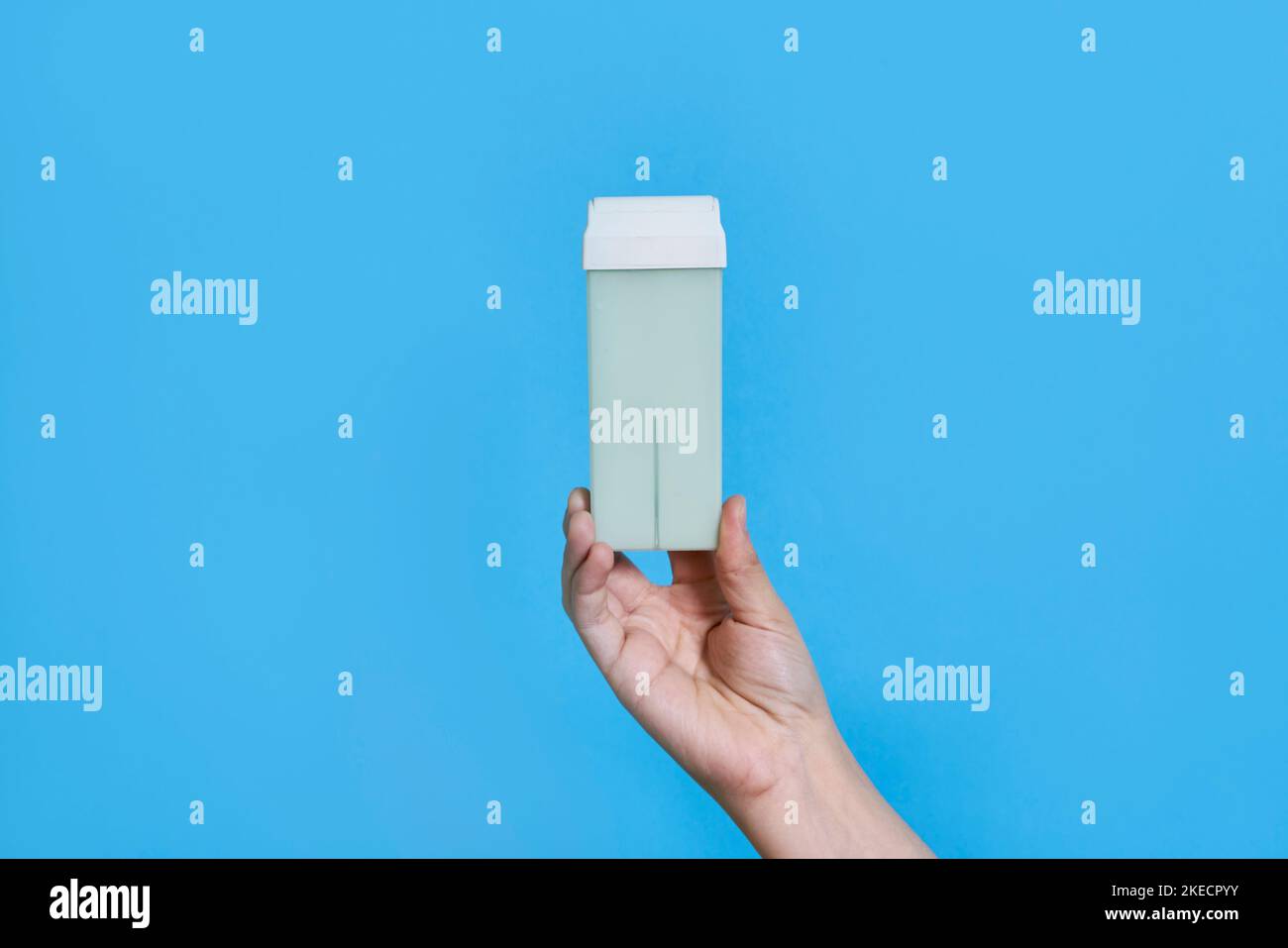someone's hand holding an empty white box on a blue background with ...