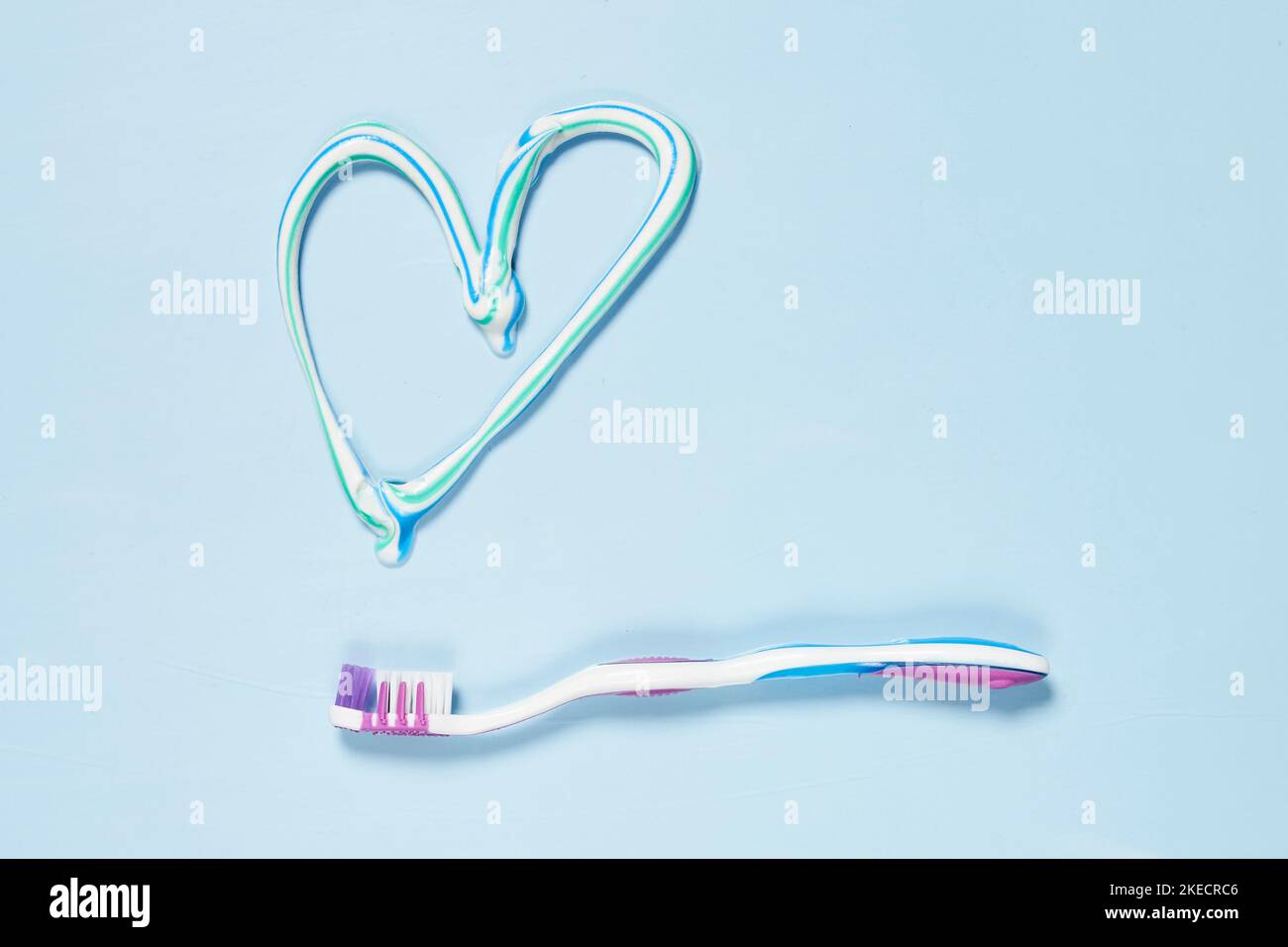 a tooth and a heart shaped toothbrush on a light blue background with ...