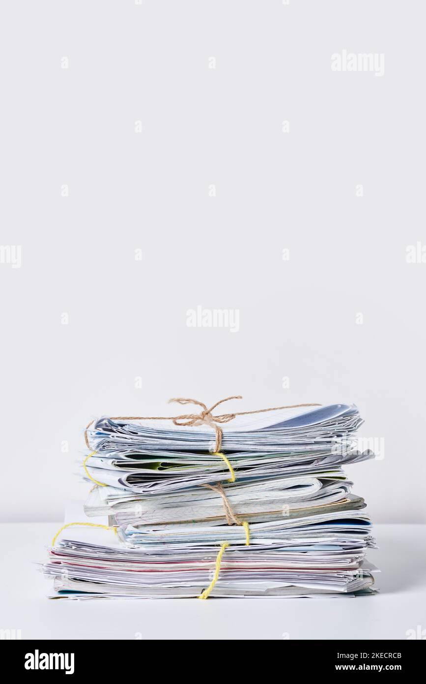 a stack of newspapers tied with twine rope on a white background stock ...