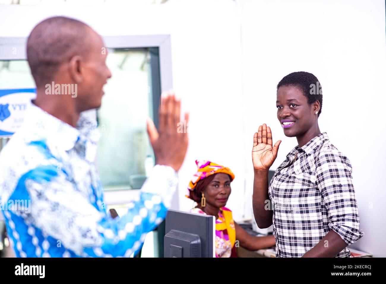 a group of young people standing in an office saying goodbye smiling ...