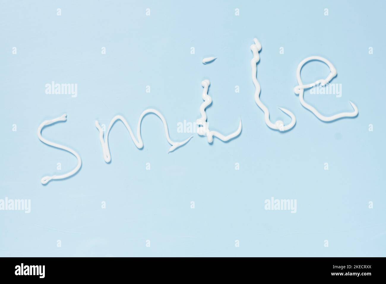 the word smile written in white paint on a blue background, with an ...