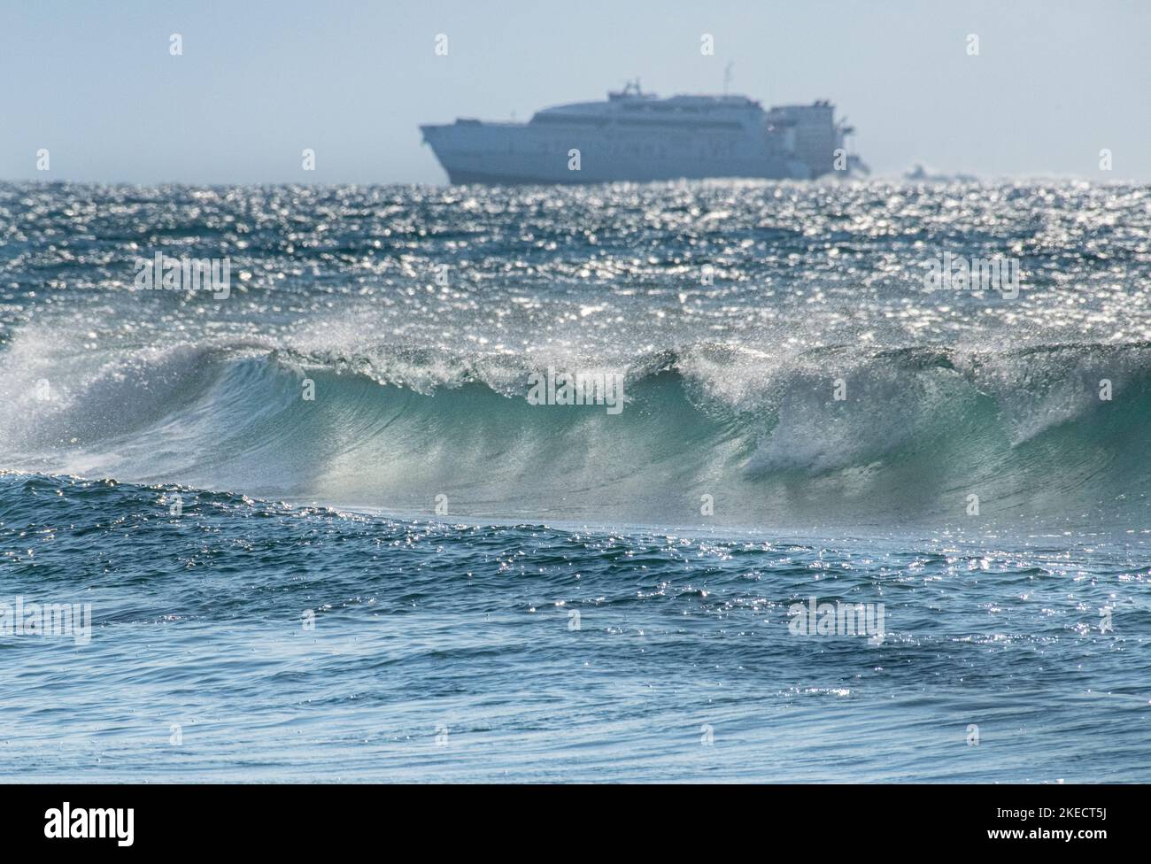 A ferry in the distance with ferocious Mediterranean waves crash onto ...
