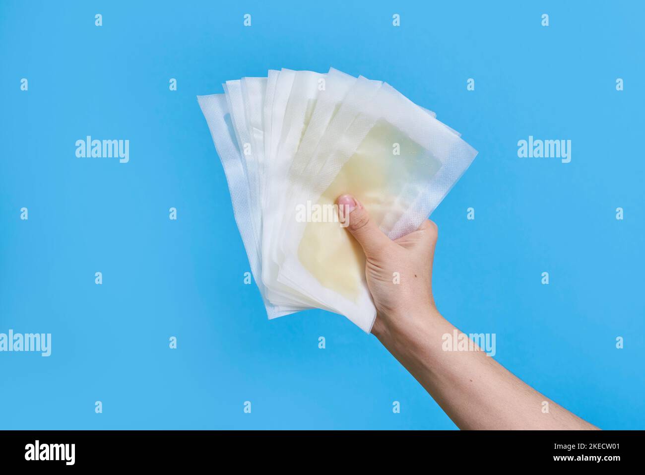 someone's hand holding a bunch of tissues on a blue background with ...