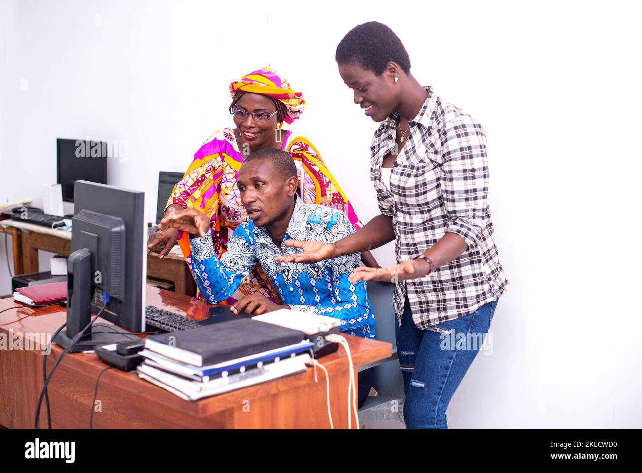 a group of young people working using a computer in an office Stock ...