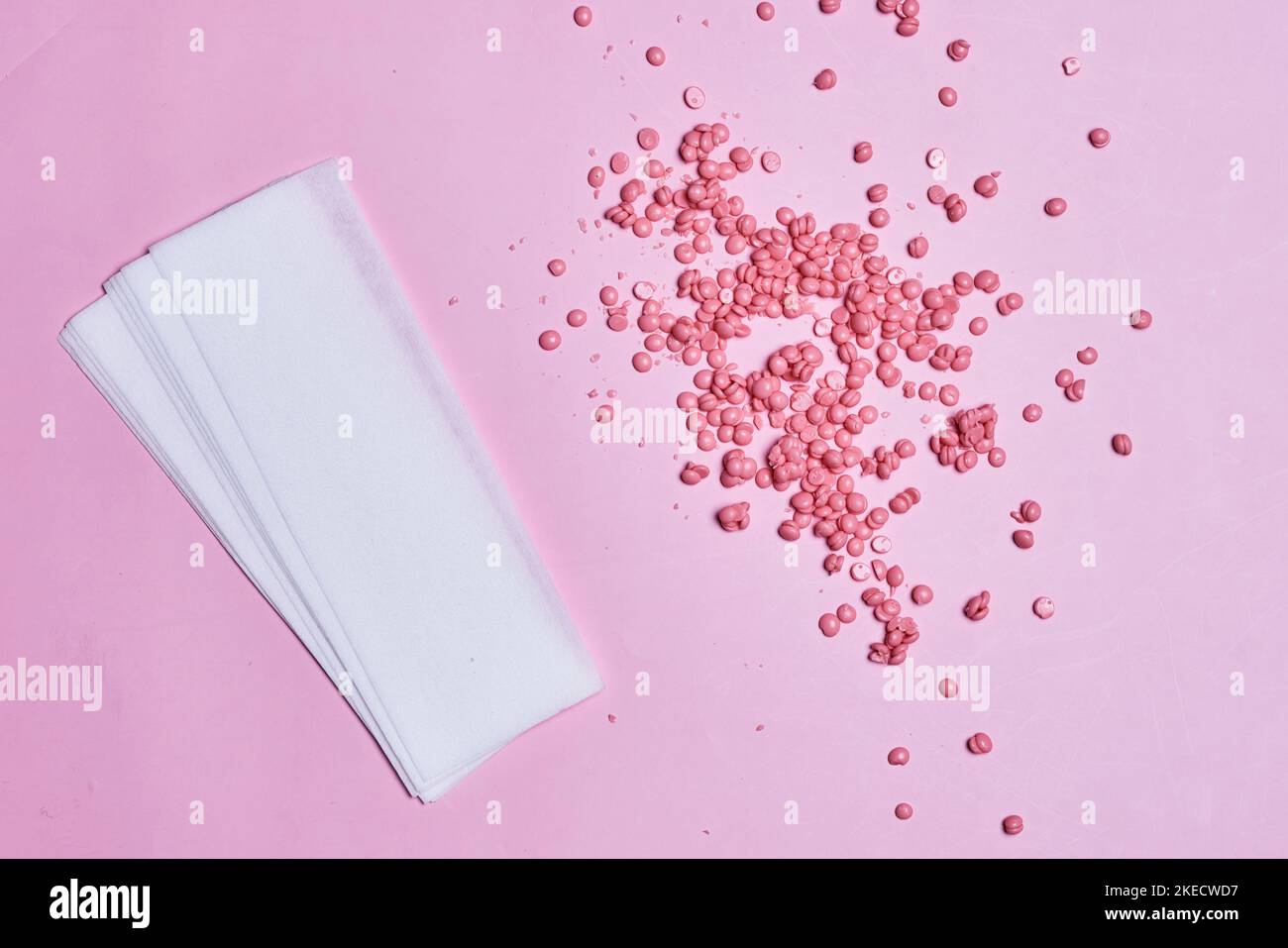pink pills spilling out of a white napkin on a pink background with ...
