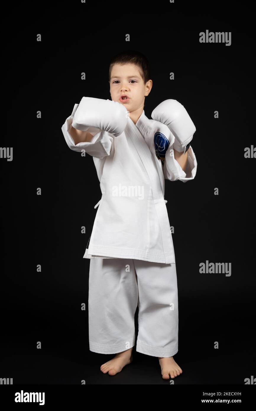 A little boy learns martial arts, doing karate in kimono and boxing ...