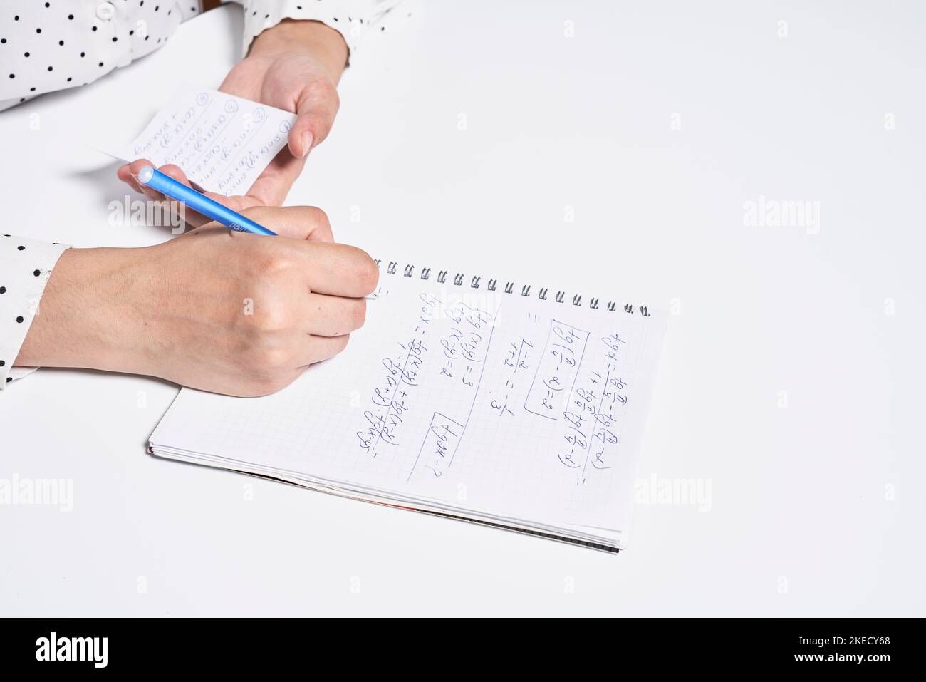someone's hand holding a pen and writing on a piece of paper that has ...