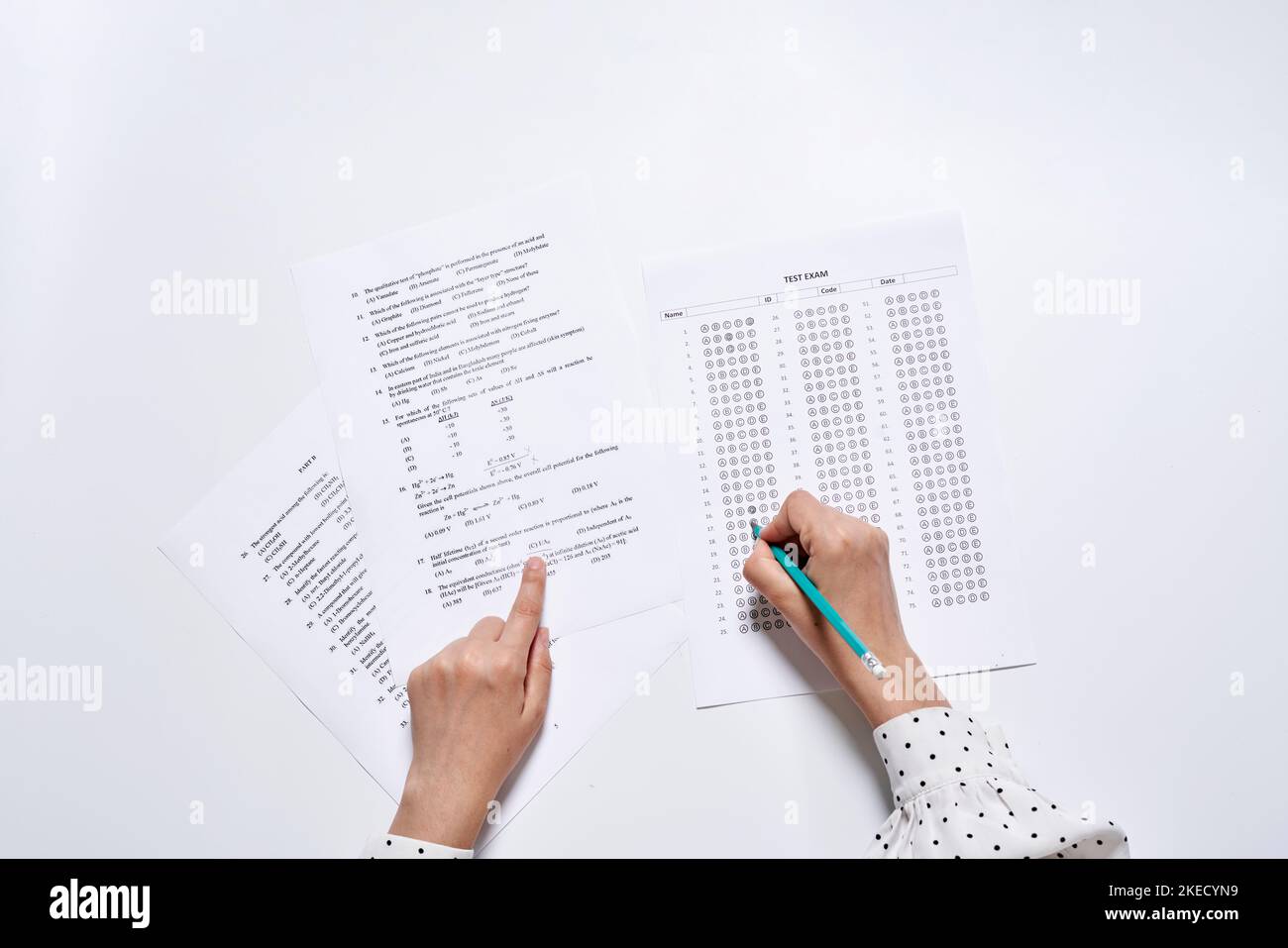 two hands holding papers that have been written out on them, and one ...