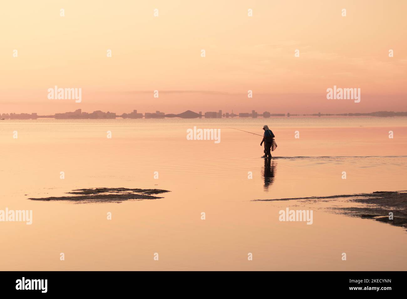 Traditional fisherman fishing with a rod at sunrise in the Mar Menor ...