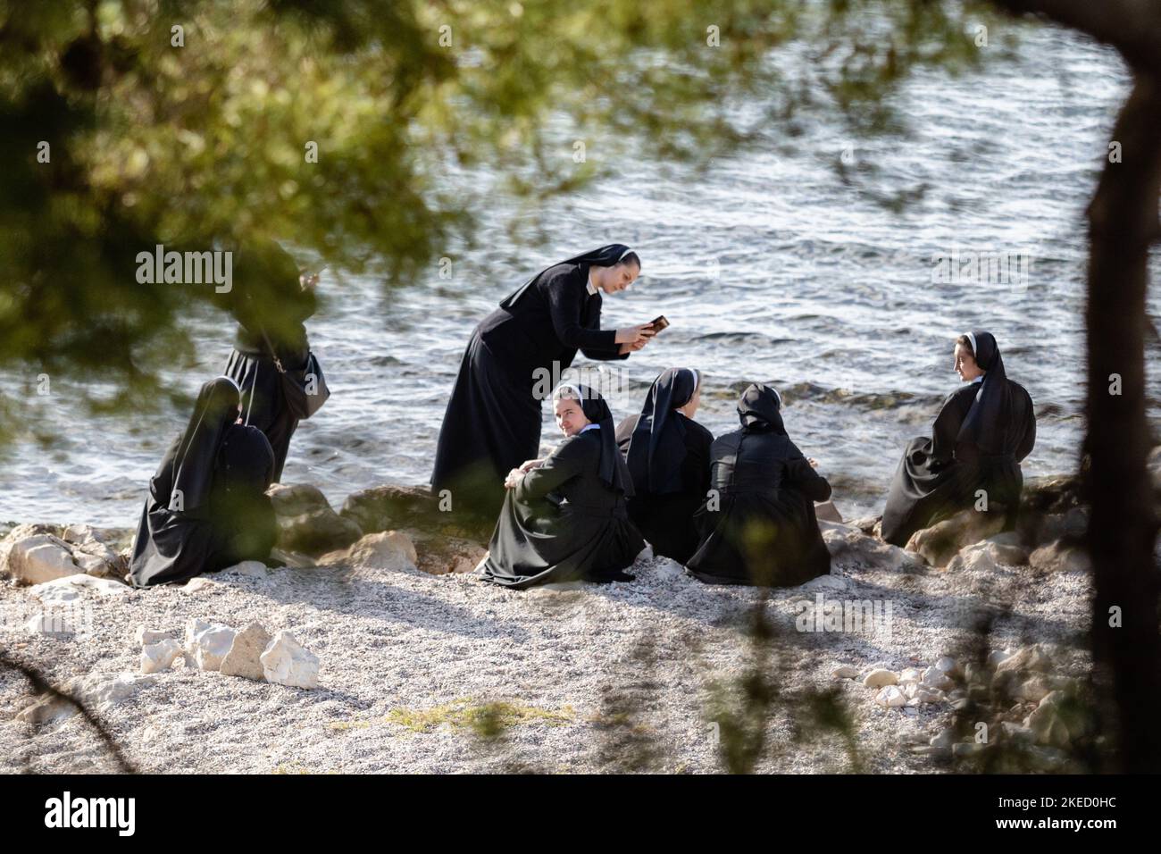 Nuns having fun and taking photos by the sea during a sunny day i ...