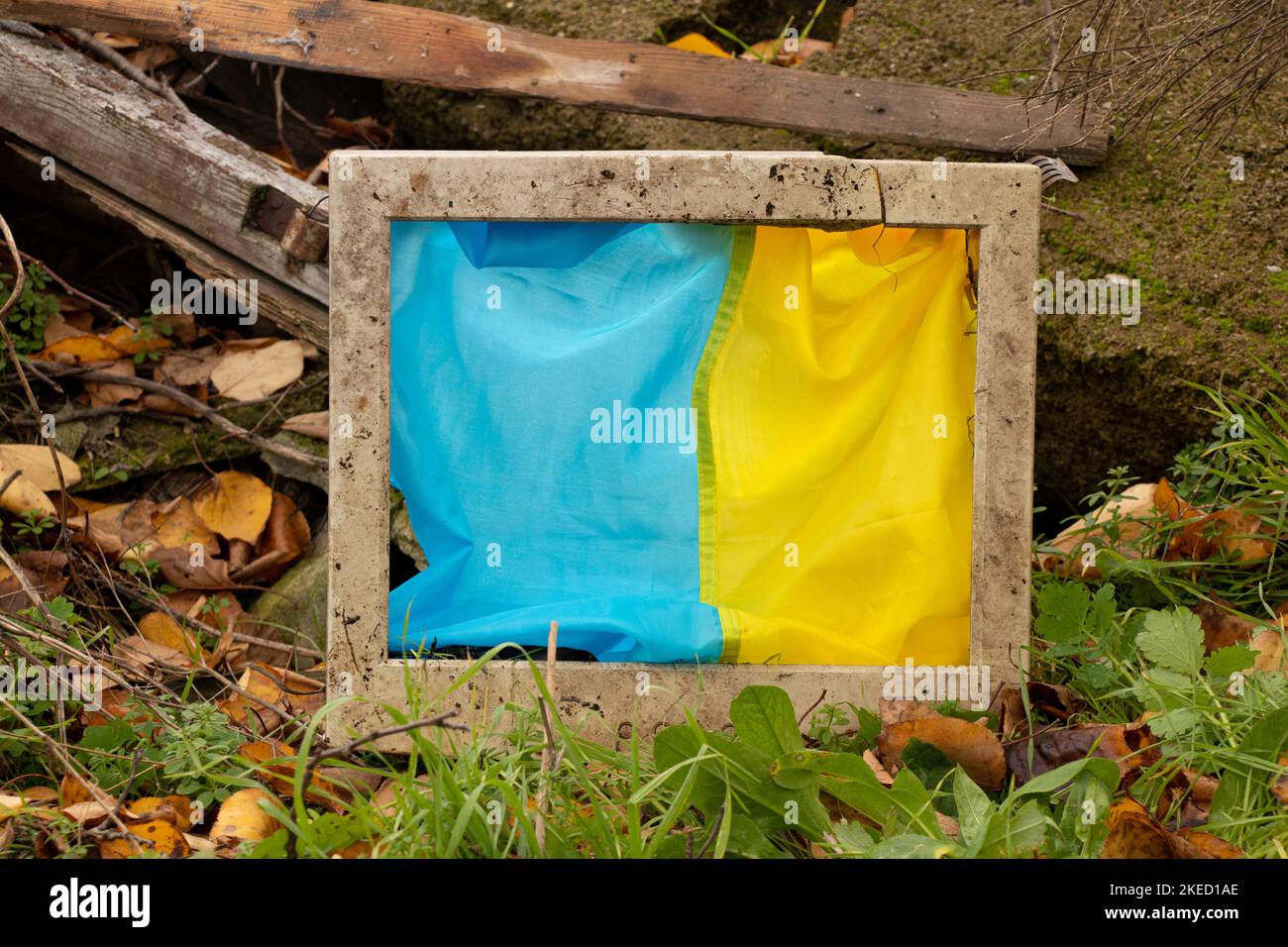The flag of Ukraine hangs in an old broken computer screen on the ruins ...