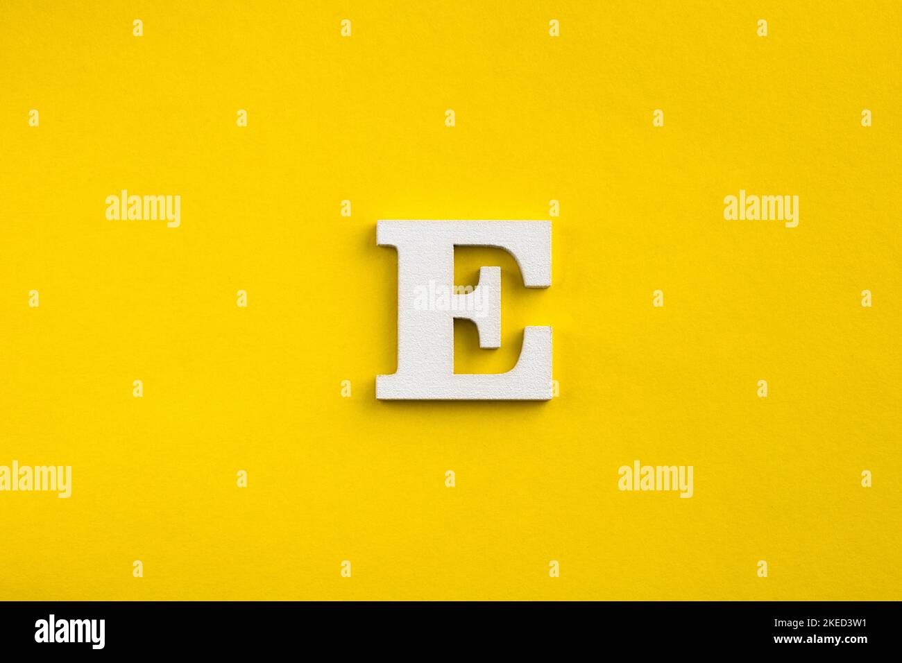 letter E uppercase - white wood letter on yellow color background Stock ...
