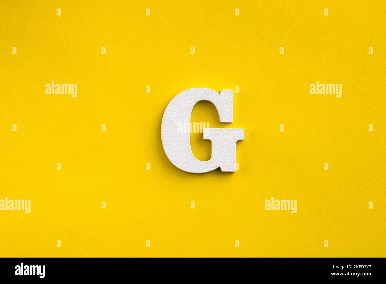 letter G uppercase - white wood letter on yellow color background Stock ...