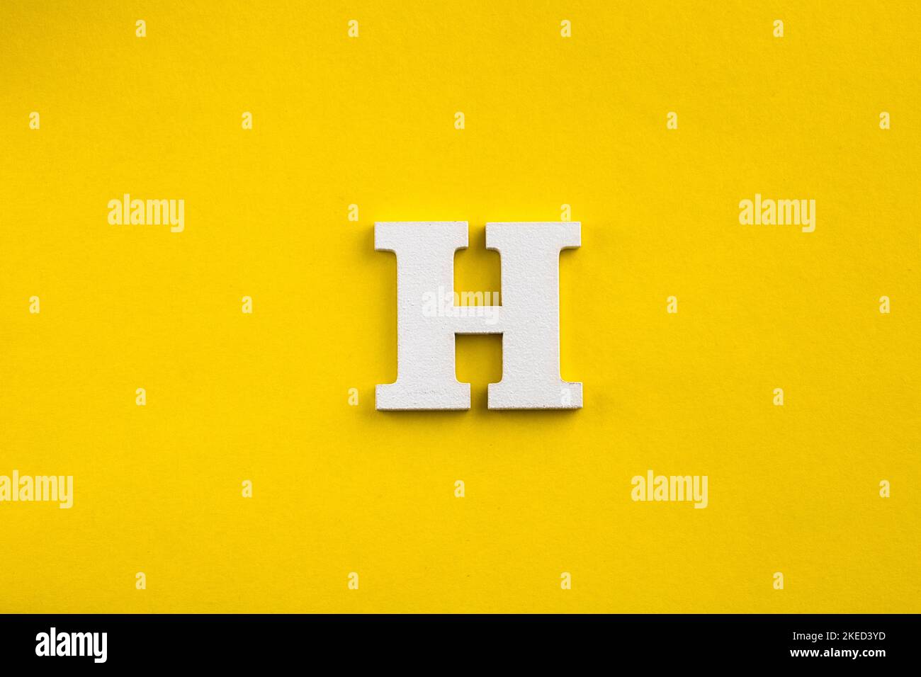 Alphabet letter H - White wood letter on yellow colored background ...