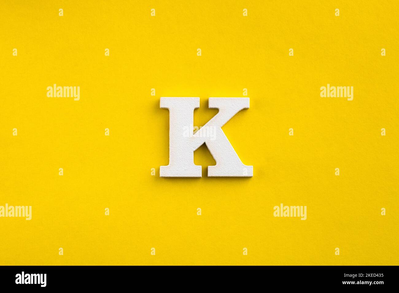 letter K uppercase - white wood letter on yellow color background Stock ...
