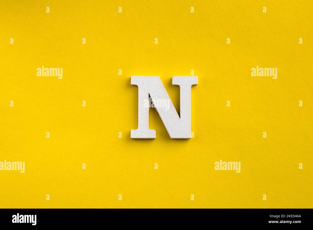 letter N uppercase - white wood letter on yellow color background Stock ...