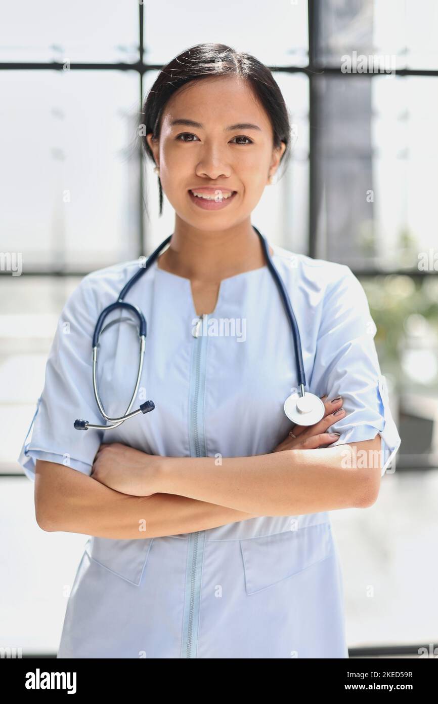 Portrait of asian female doctor looking at camera with arms crossed ...