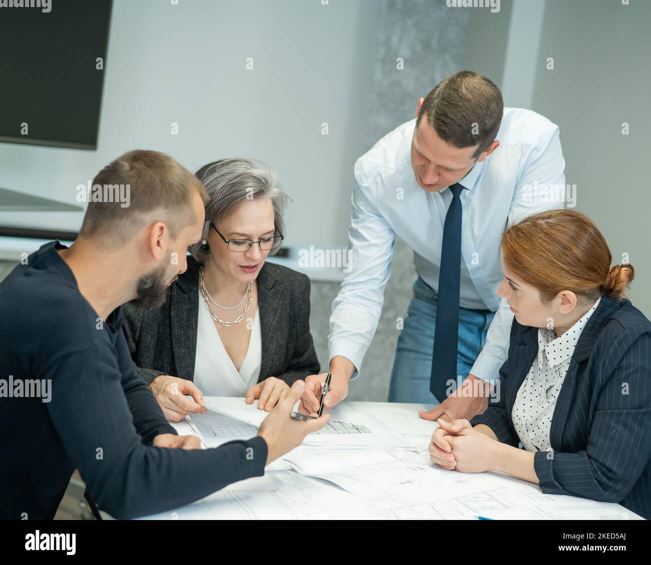 The boss gives instructions to three employees in the office conference ...