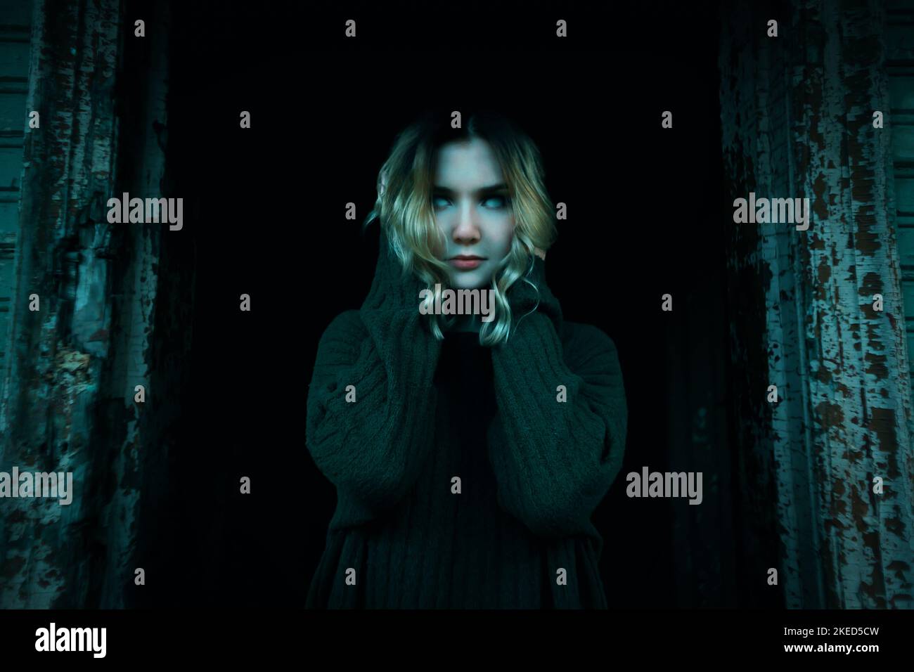 In the dark doorway of an abandoned old house stands a demon-possessed ...