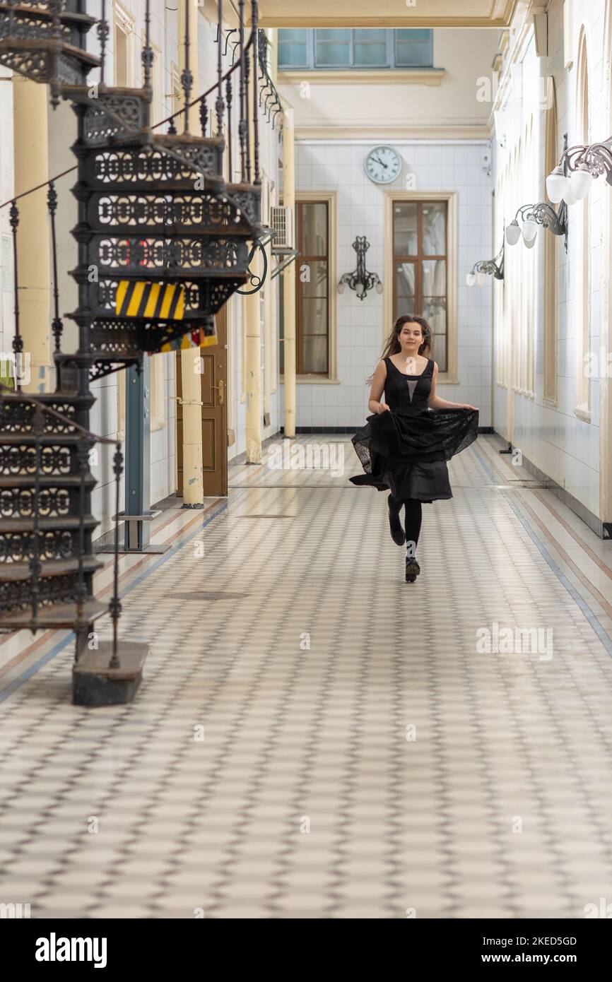 Beautiful girl in black dress running in hall checkered floor. High ...