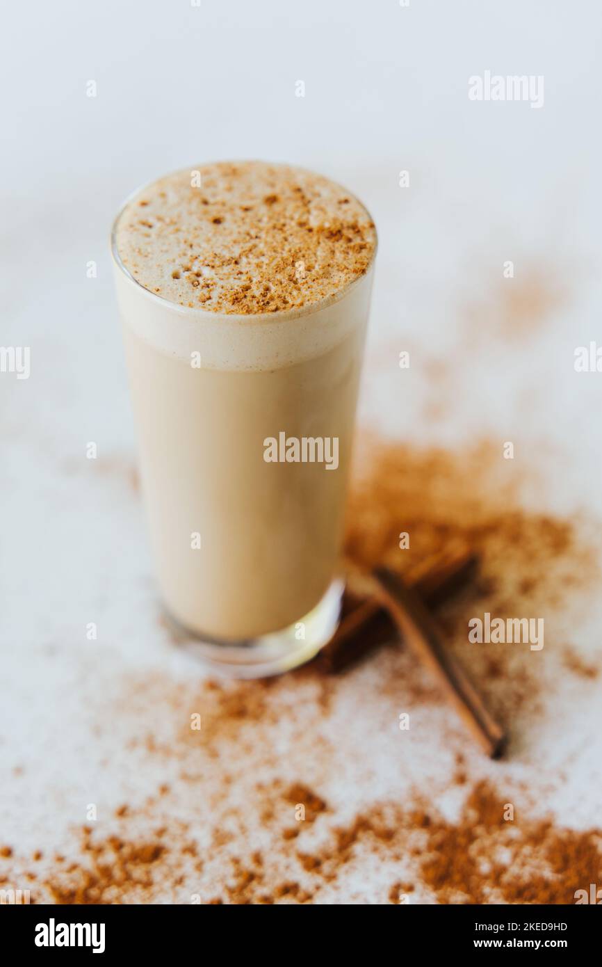 A closeup shot of a glass of a beige cinnamon mocha shake, sprinkled ...