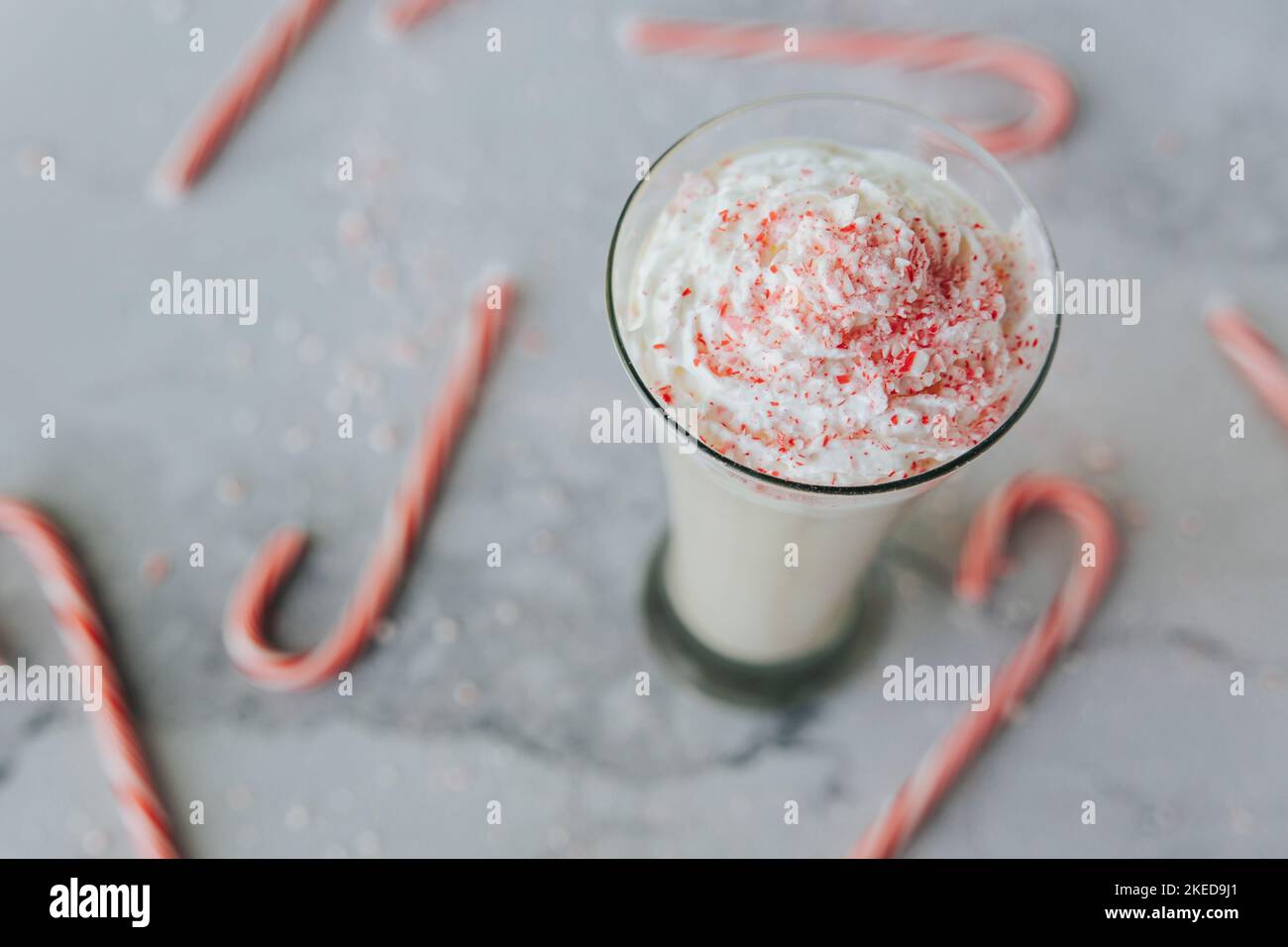 A top view of a glass of candy cane shake, sprinkled with candy cane ...