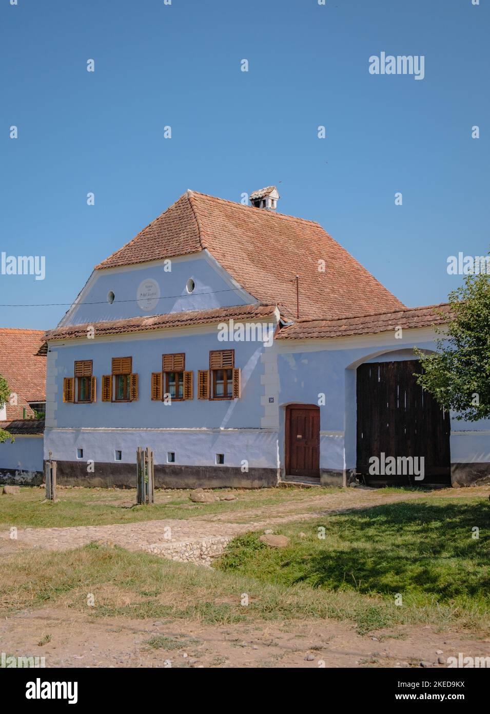 A vertical shot of a blue house around the Viscri UNESCO Heritage Site ...