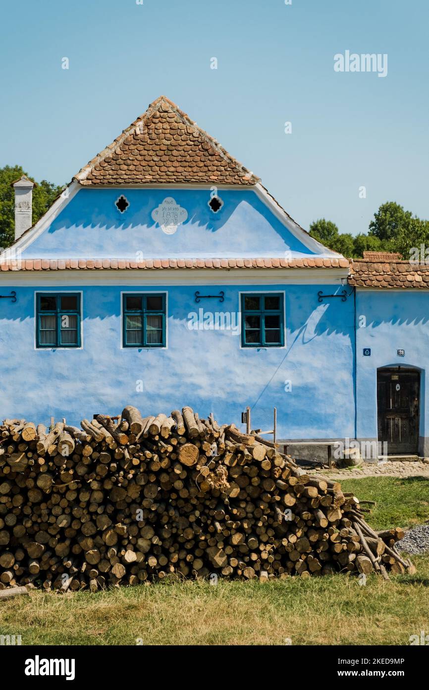 A vertical shot of a blue house around the Viscri UNESCO Heritage Site ...