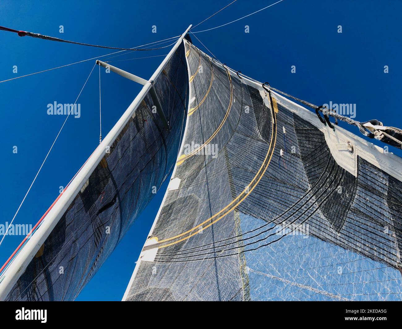 A low angle shot of a gray sailboat sail in a blue sky Stock Photo - Alamy