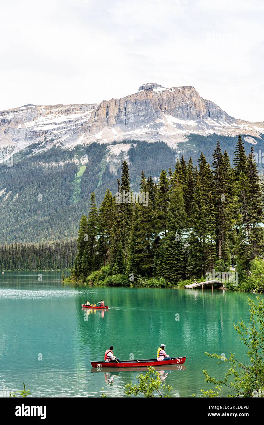 A vertical shot of the freshwater Emerald Lake and red canoes in Yoho ...