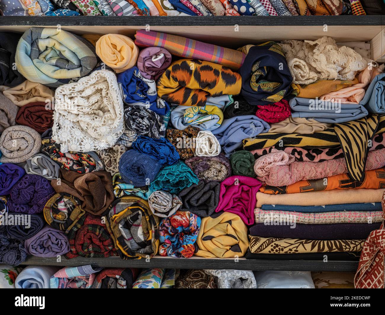 Folded and rolled fabrics on wooden shelves in drapery Stock Photo - Alamy