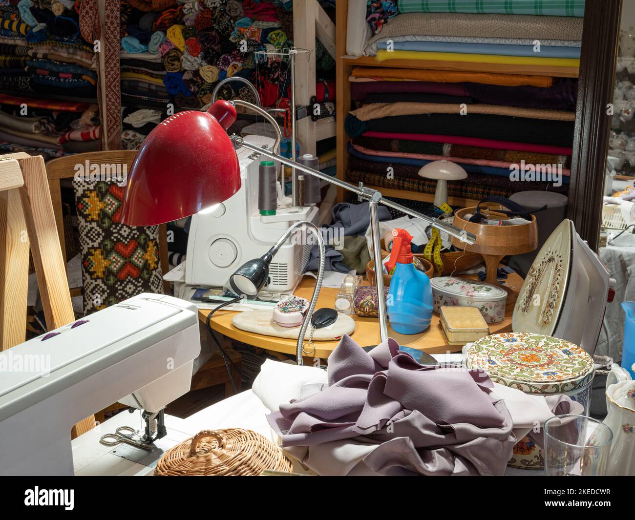 Tailor's workplace. Fabrics on wooden shelves. Sewing machines Stock ...
