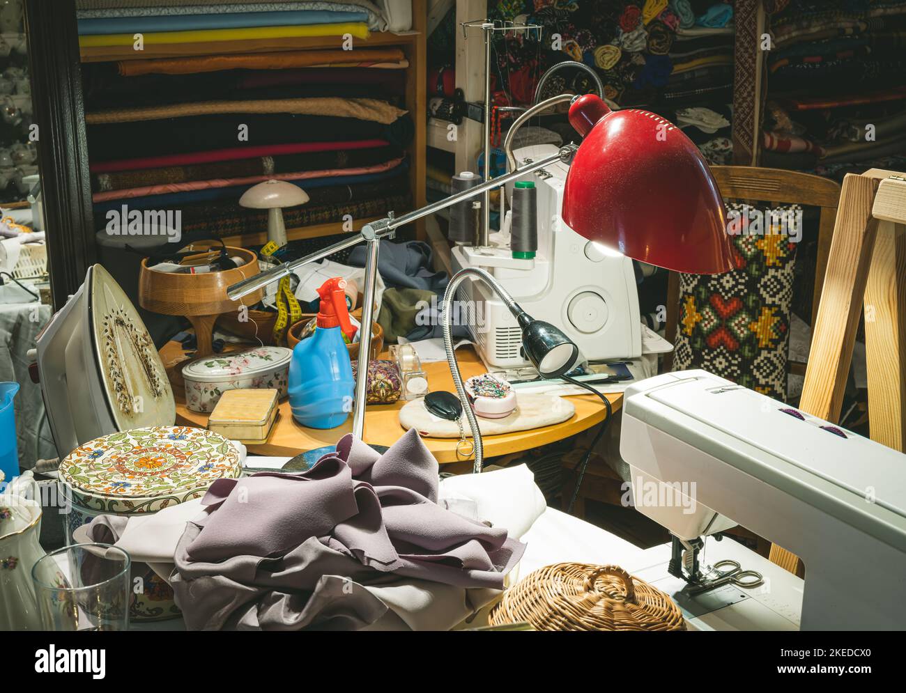 Tailor's workplace. Fabrics on wooden shelves. Sewing machines Stock ...