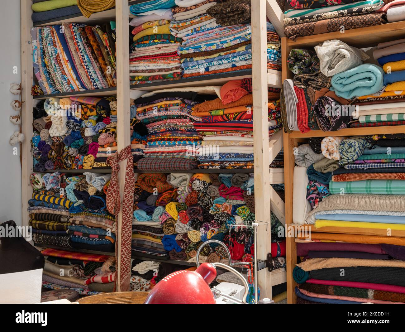 Tailor's workplace. Folded and rolled fabrics on wooden shelves Stock ...