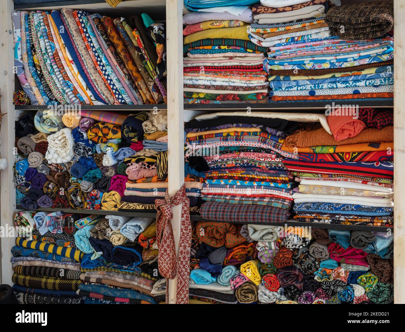 Folded and rolled fabrics on wooden shelves in drapery Stock Photo - Alamy