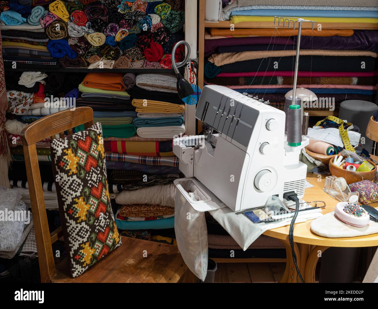 Tailor's workplace. Fabrics on wooden shelves. Sewing machines Stock ...