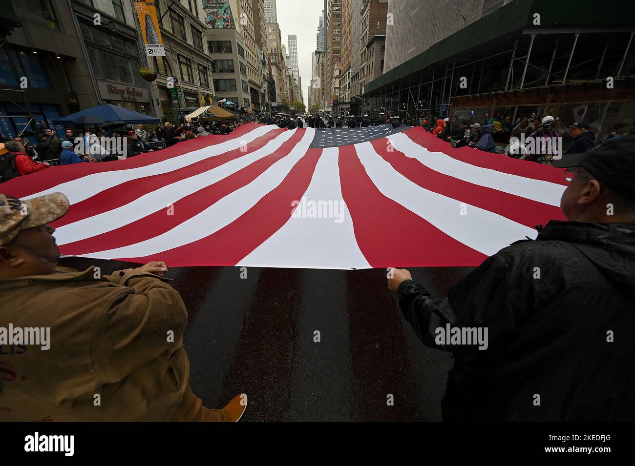 Military veterans hold an American flag as they march up Fifth Avenue during the annual New York ...