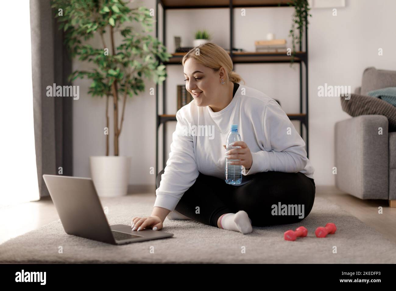 Woman doing workout with laptop Stock Photo - Alamy