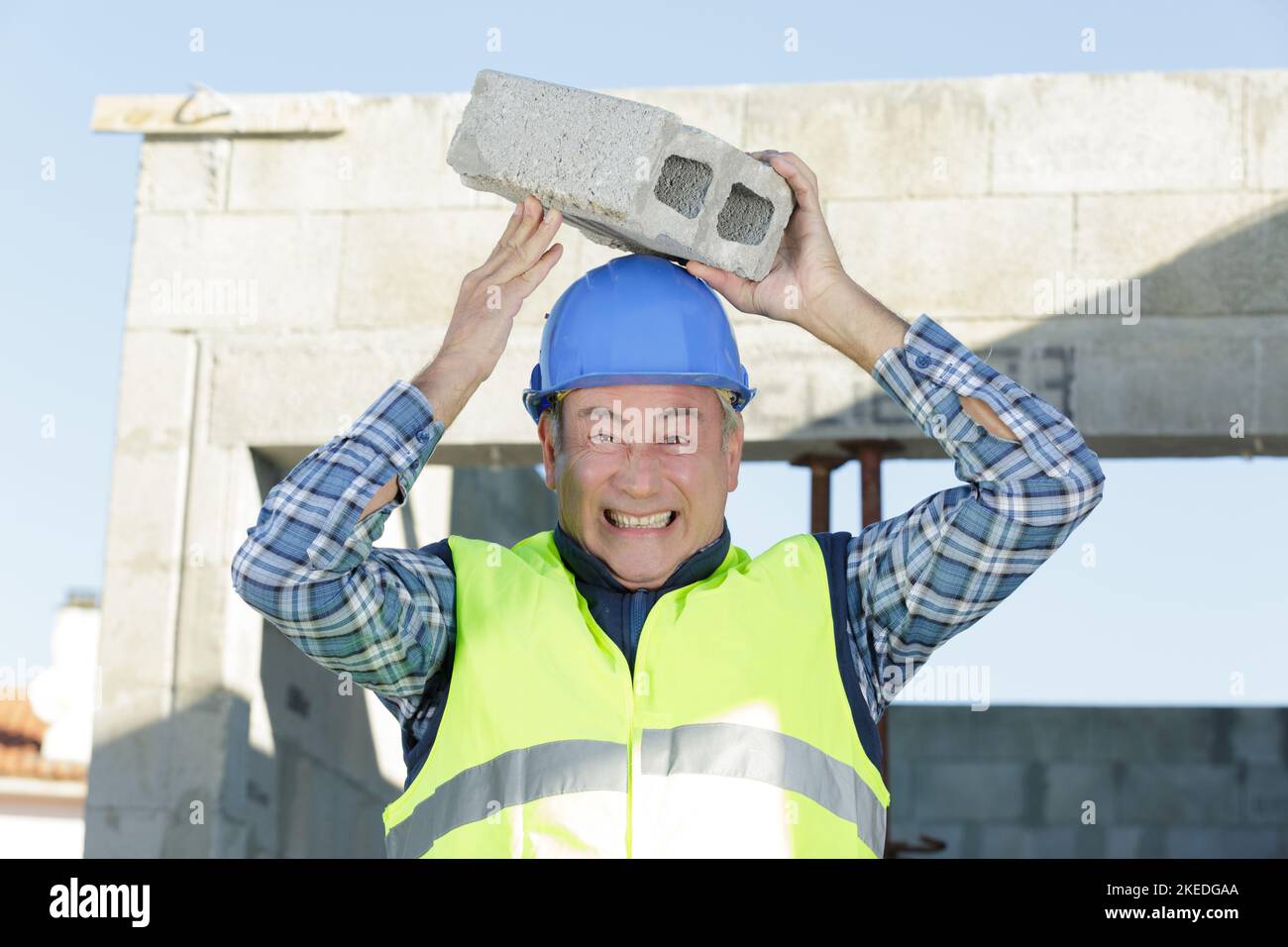 man with concrete block on his safety helmet Stock Photo - Alamy
