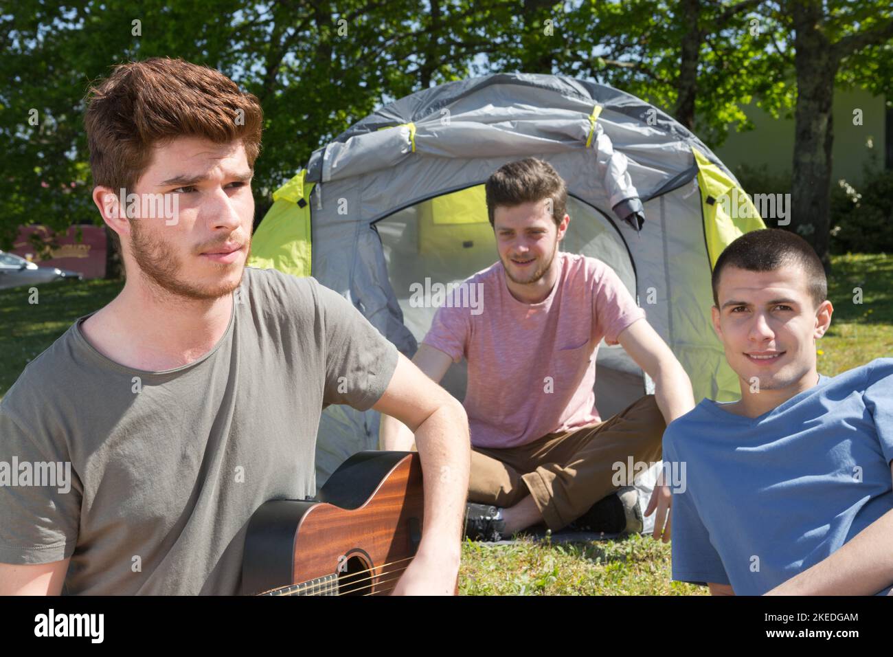 three friends on a camping Stock Photo - Alamy