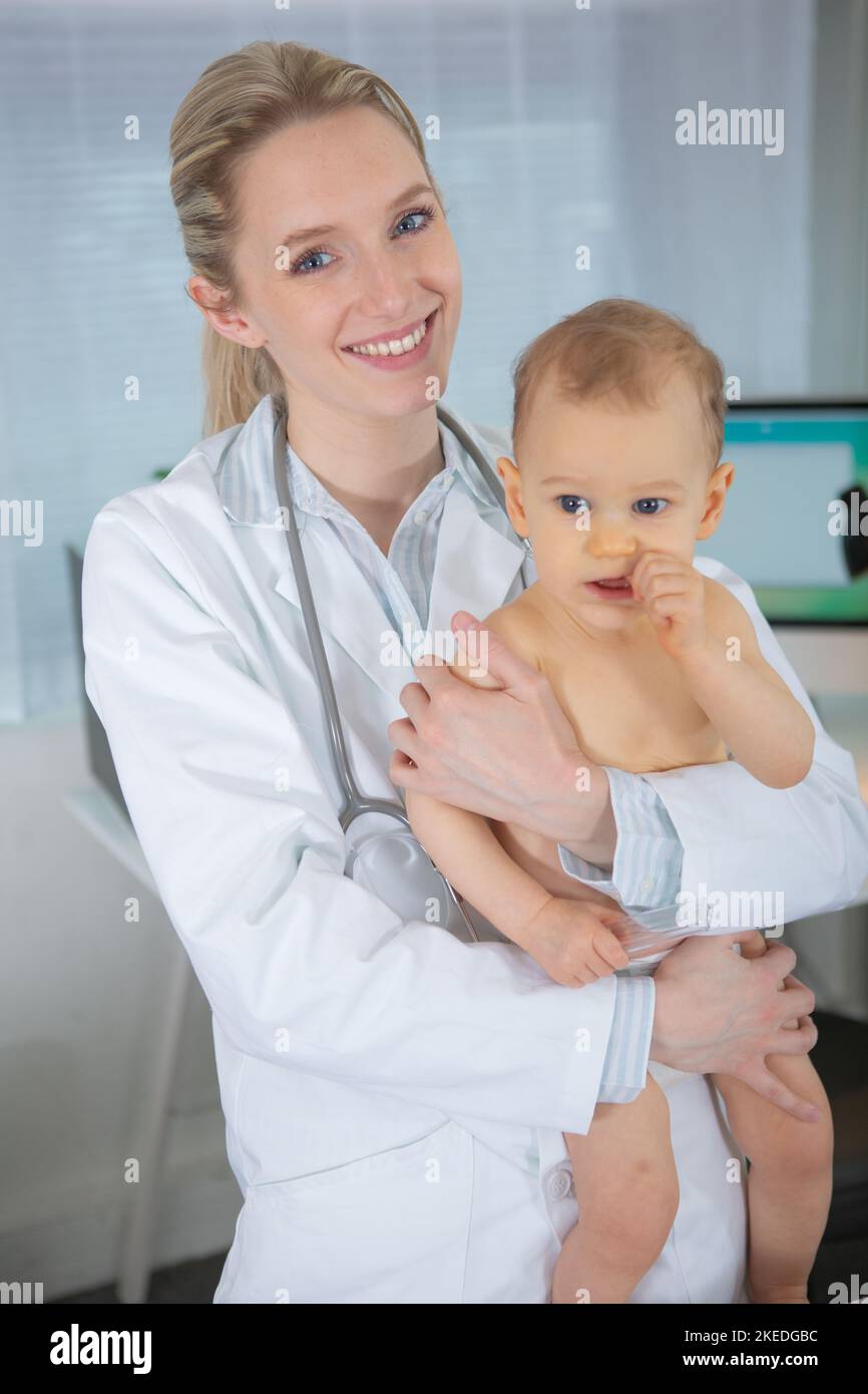 happy smiling doctor holding baby in clinic Stock Photo - Alamy