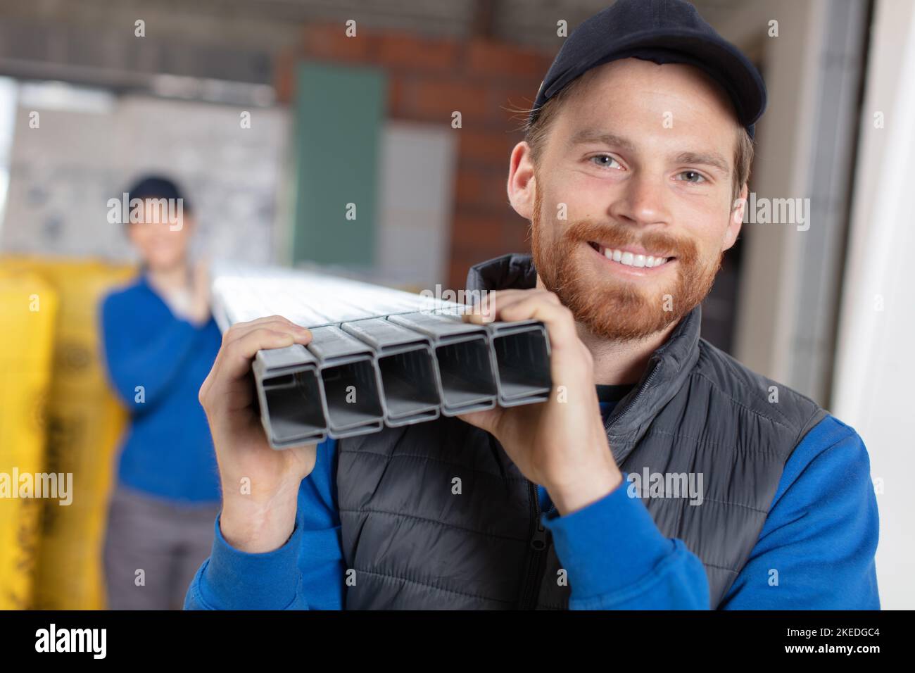 man as builder carrying bar and working Stock Photo - Alamy