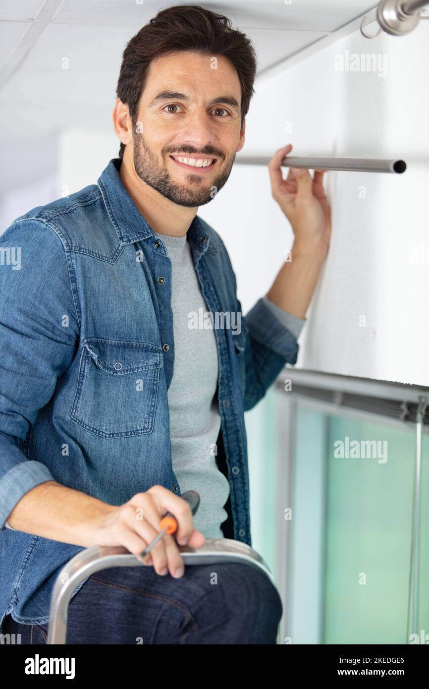 man fixing a curtain rail Stock Photo - Alamy