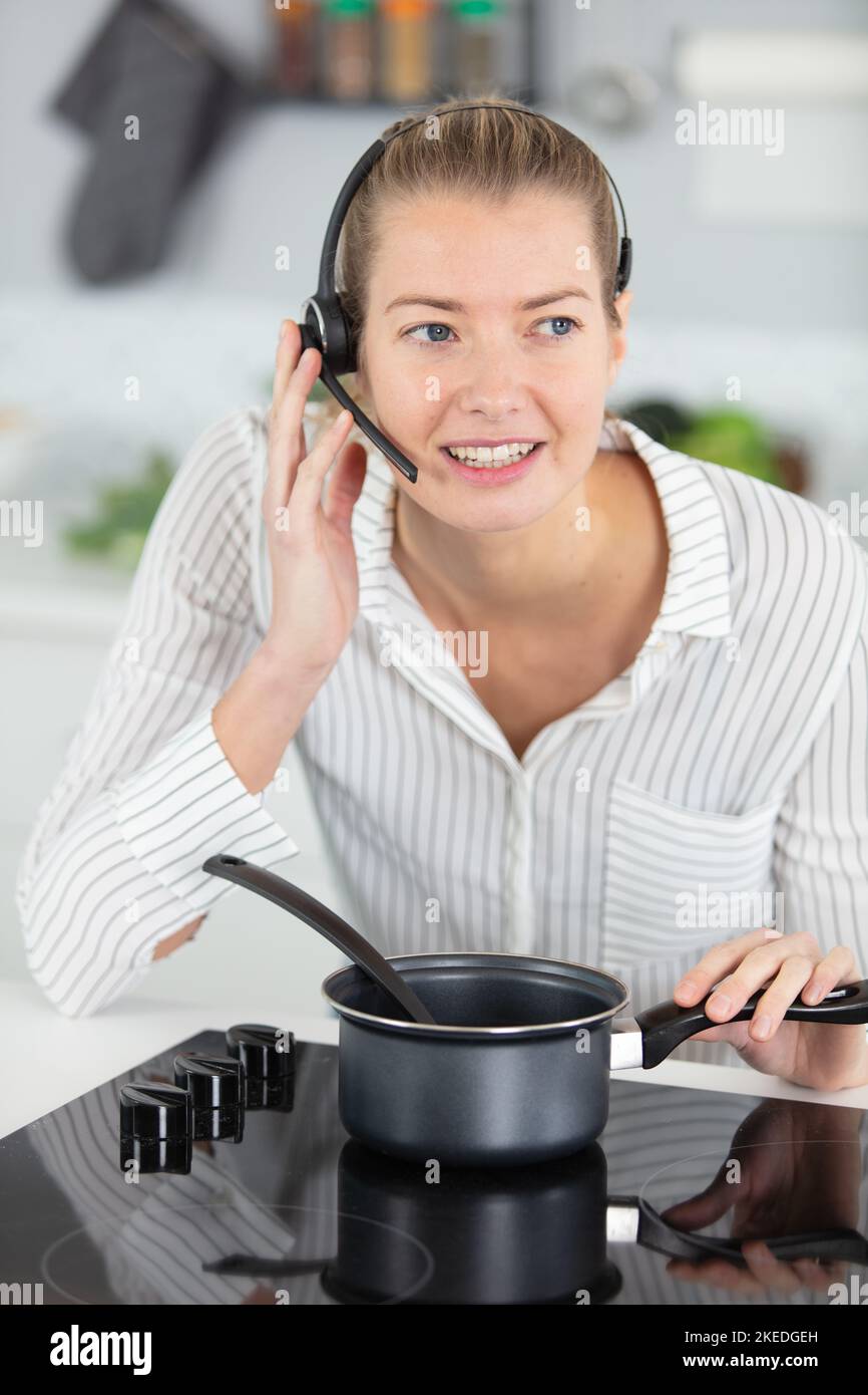 business woman having work conference call from home while cooking ...