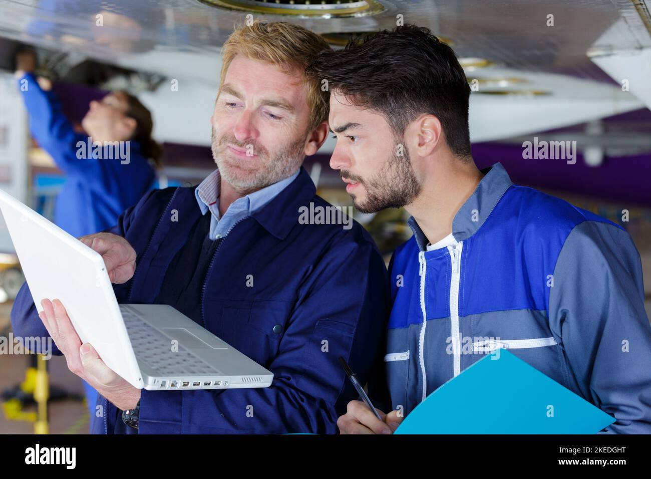 worker showing laptop screen to trainee Stock Photo - Alamy