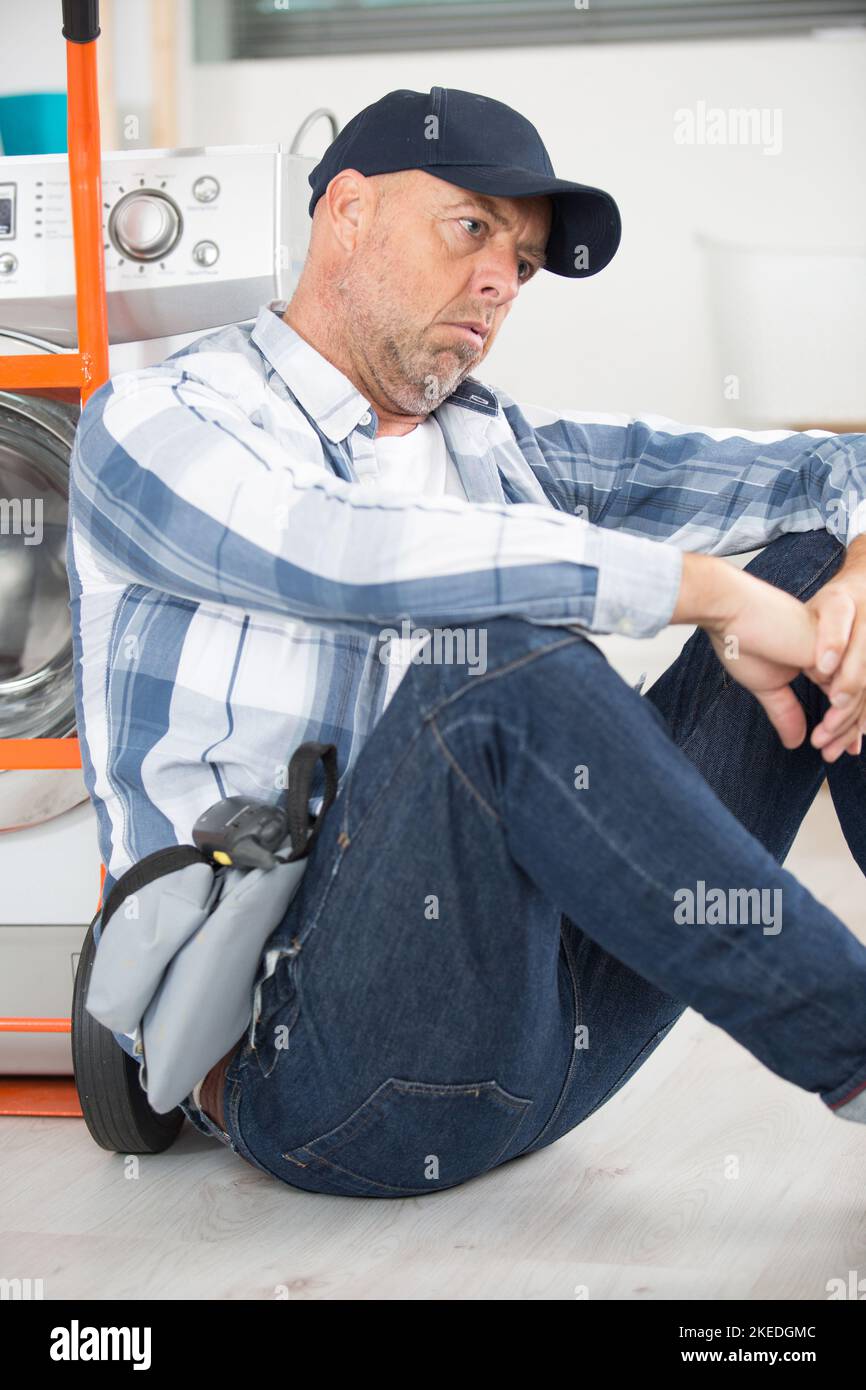 tired delivery man sitting on the floor Stock Photo - Alamy