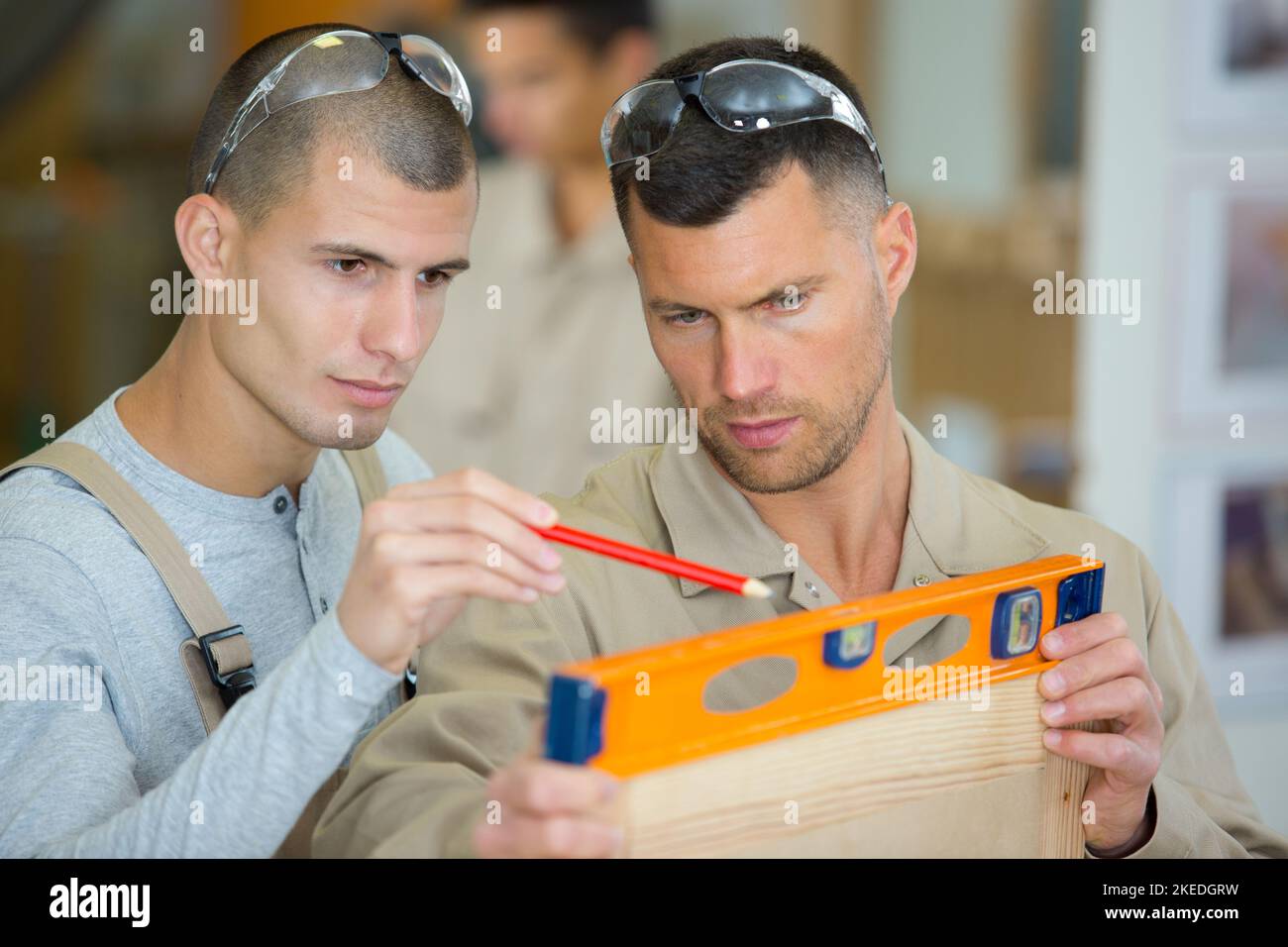 young builder reading spirit level result Stock Photo - Alamy