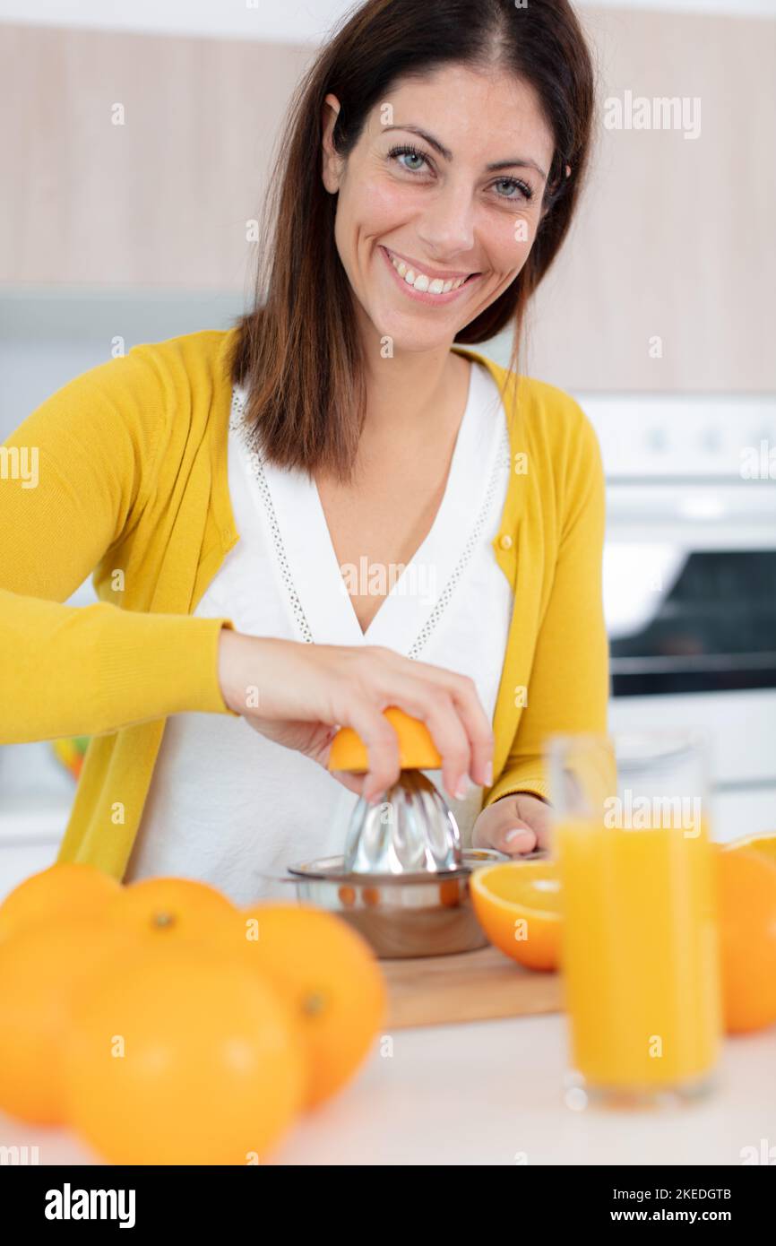 young woman in the kitchen squeezing orange juice Stock Photo - Alamy