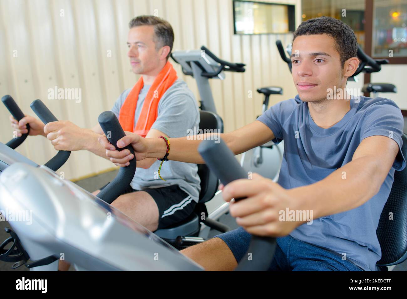 Two men using gym equipment Stock Photo - Alamy